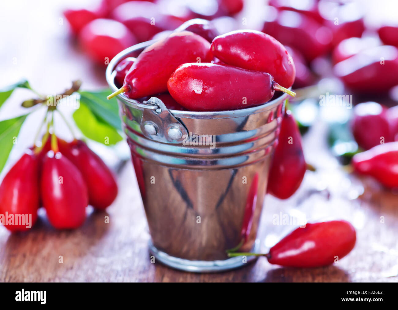 fresh cornus on the wooden table, red cornus Stock Photo - Alamy