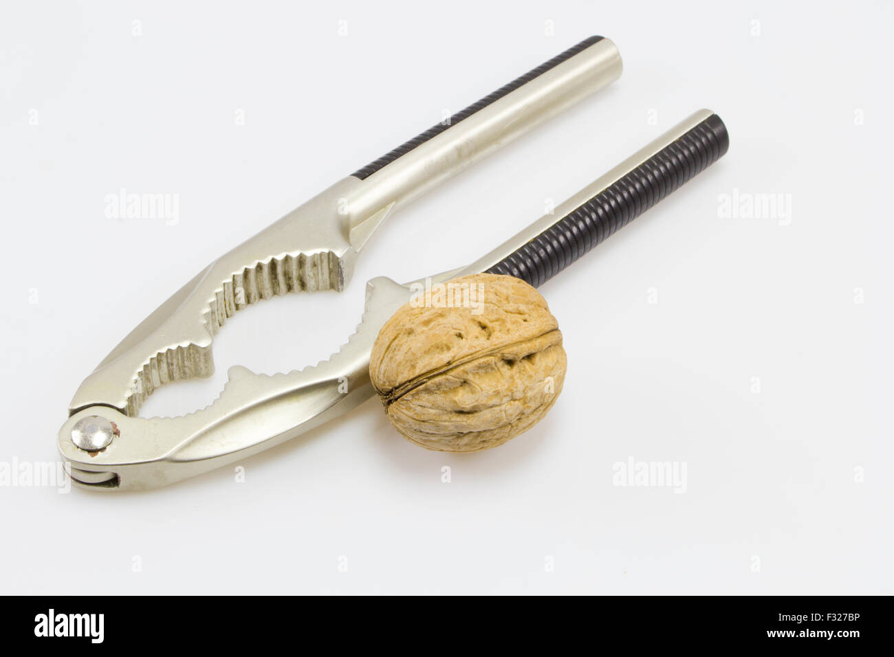 Nutcracker and a walnut isolated on a white background Stock Photo - Alamy