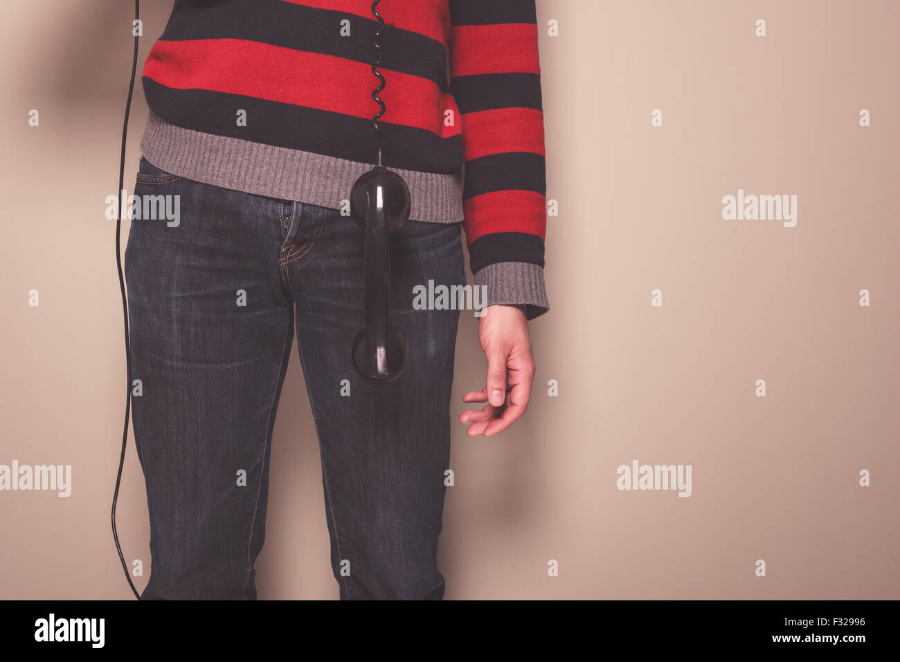 A man is dangling a telephone receiver by it's cord Stock Photo - Alamy