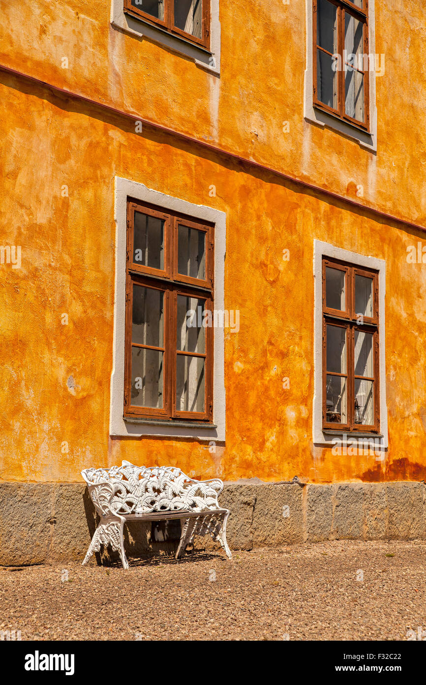 Image of a bright orange building with a bench by the wall Stock Photo ...