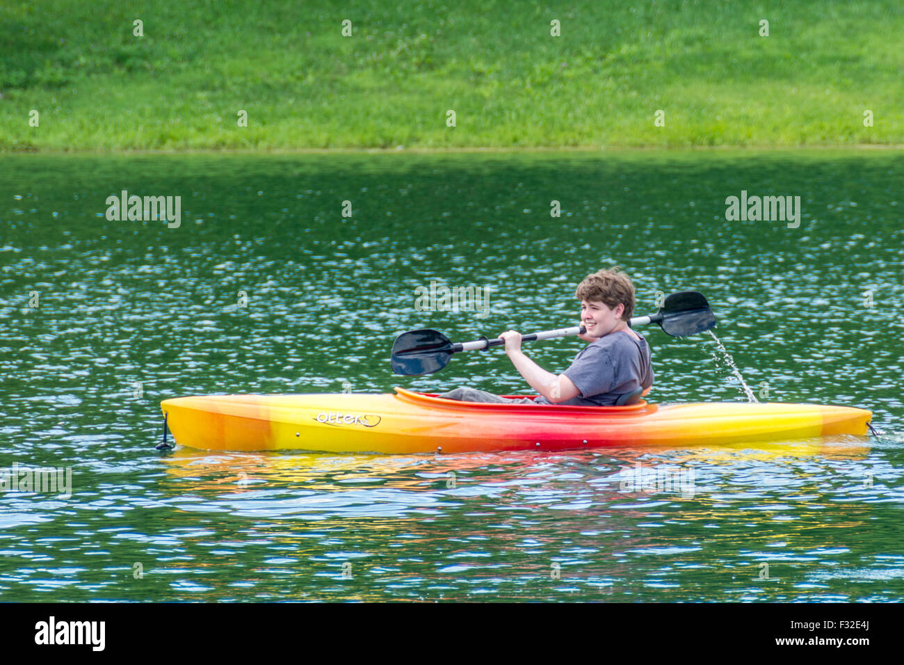 Teenage boy kayaking on a lake Stock Photo - Alamy