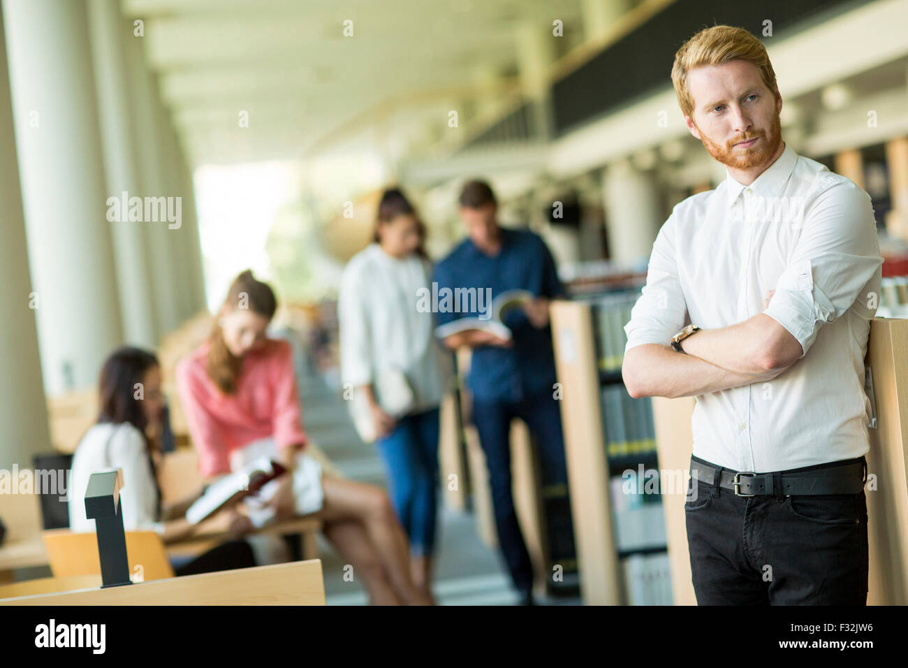 Young man in the library Stock Photo - Alamy
