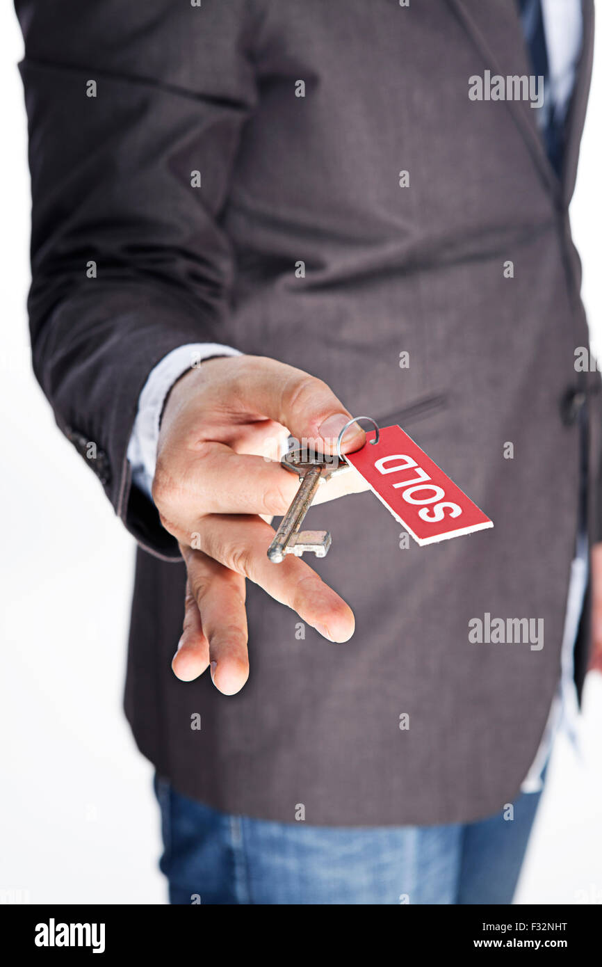 Realtor Holding Up Old Key with Red SOLD Sign Stock Photo - Alamy