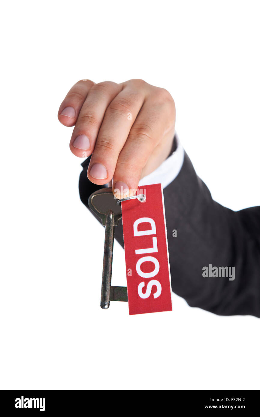 Realtor Holding Up Old Key with Red SOLD Sign on the white background ...