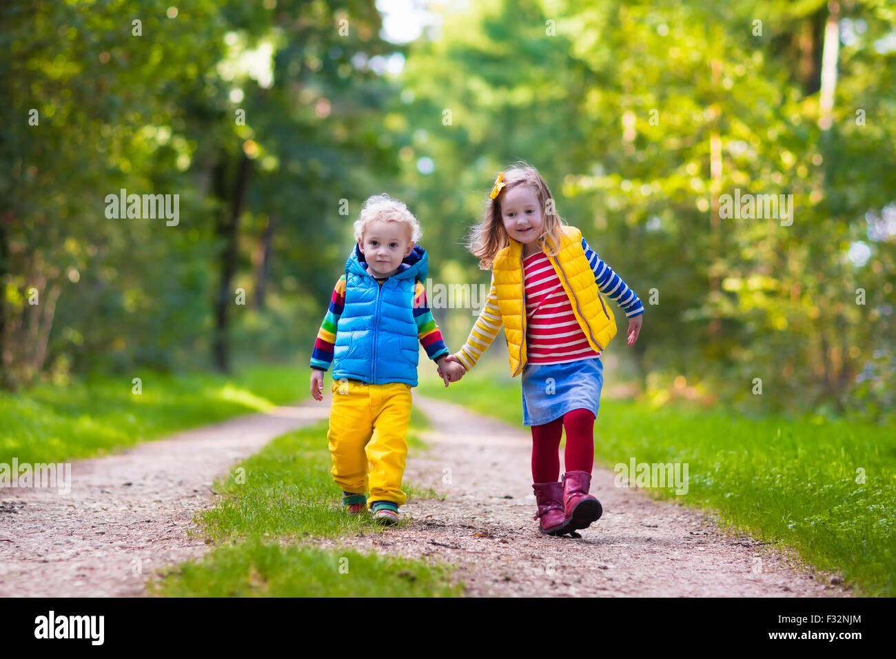 Kids playing in autumn park. Children play outdoors on a sunny fall day ...