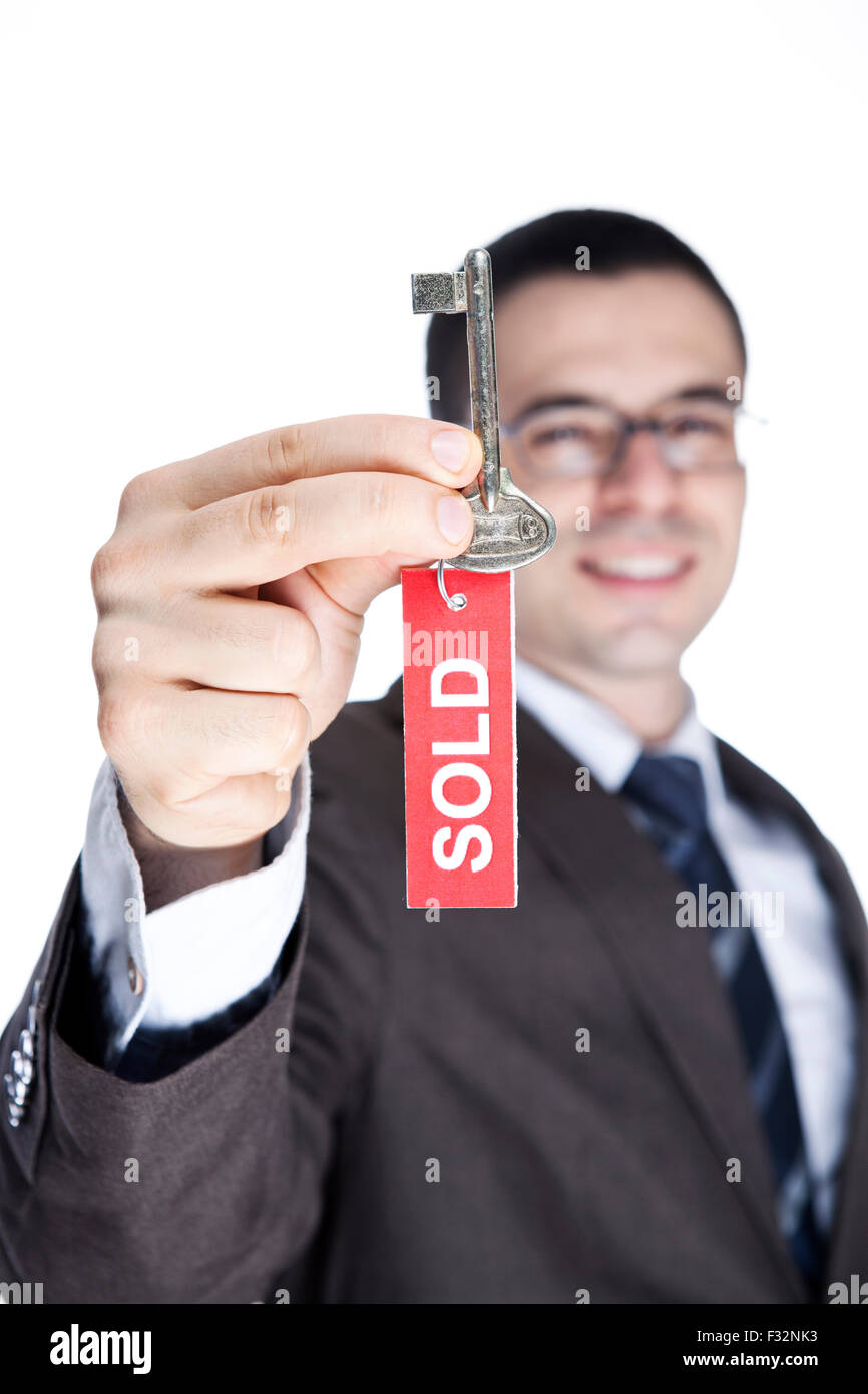 Realtor Holding Up Old Key with Red SOLD Sign Stock Photo - Alamy