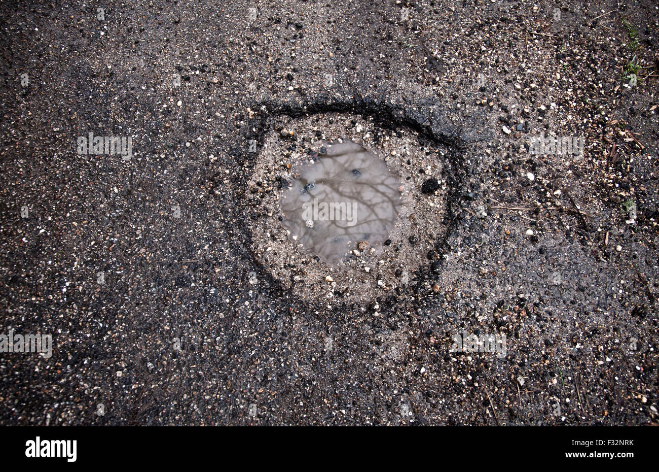 Pothole in the road, full of rain water Stock Photo - Alamy
