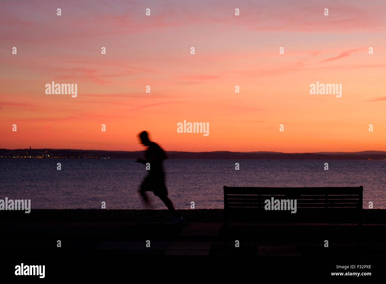 man jogging during a gorgeous sunset after a beautiful sunny day at ...
