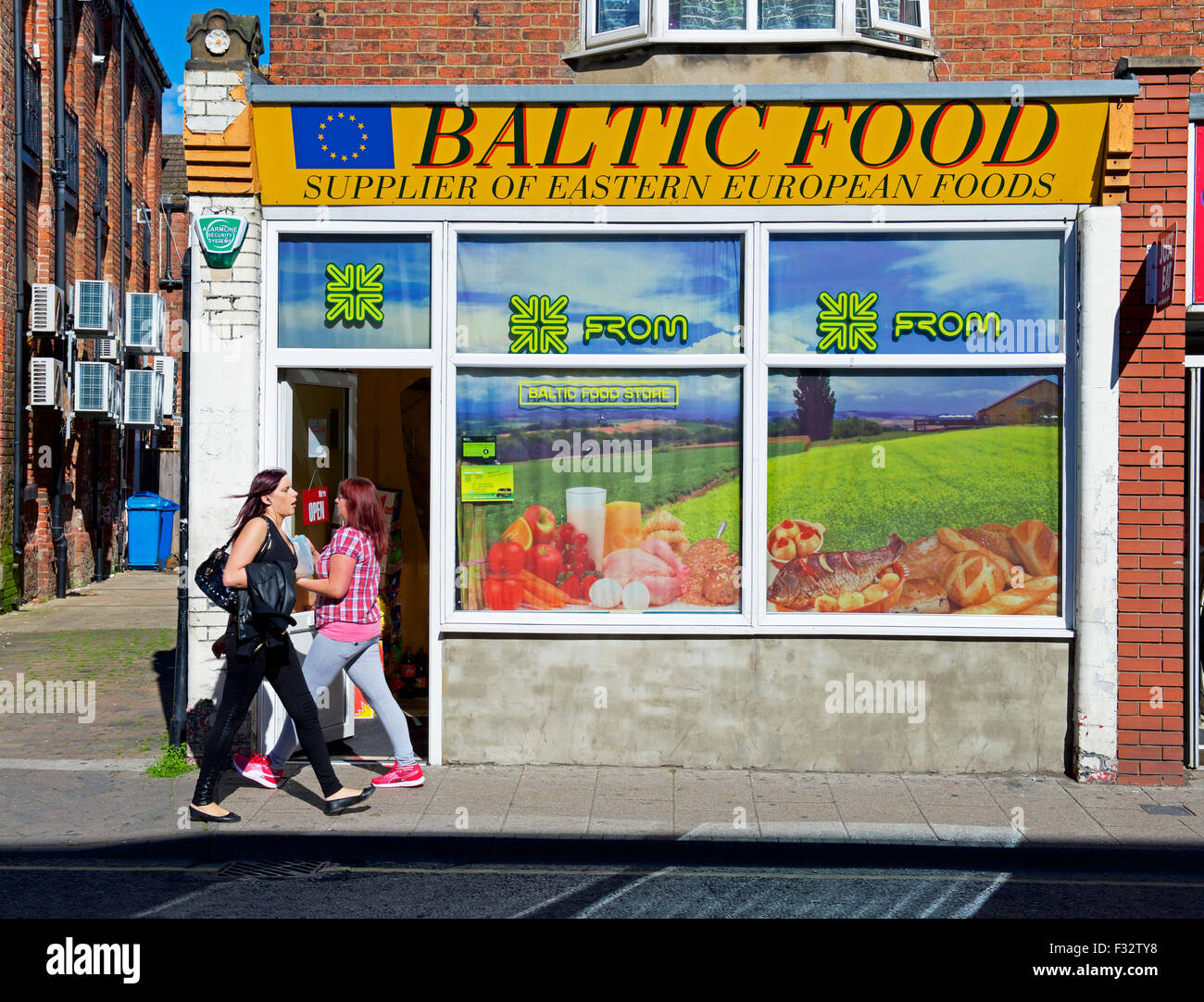 Two young women walking past shop selling East European food in Boston ...