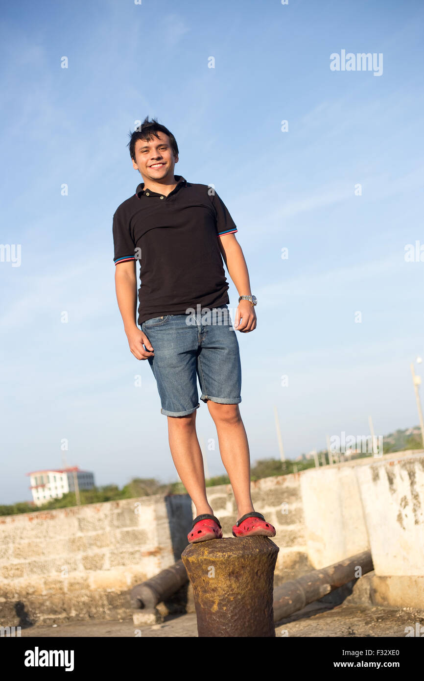 young man standing on a tall pole in Cartagenna Stock Photo - Alamy