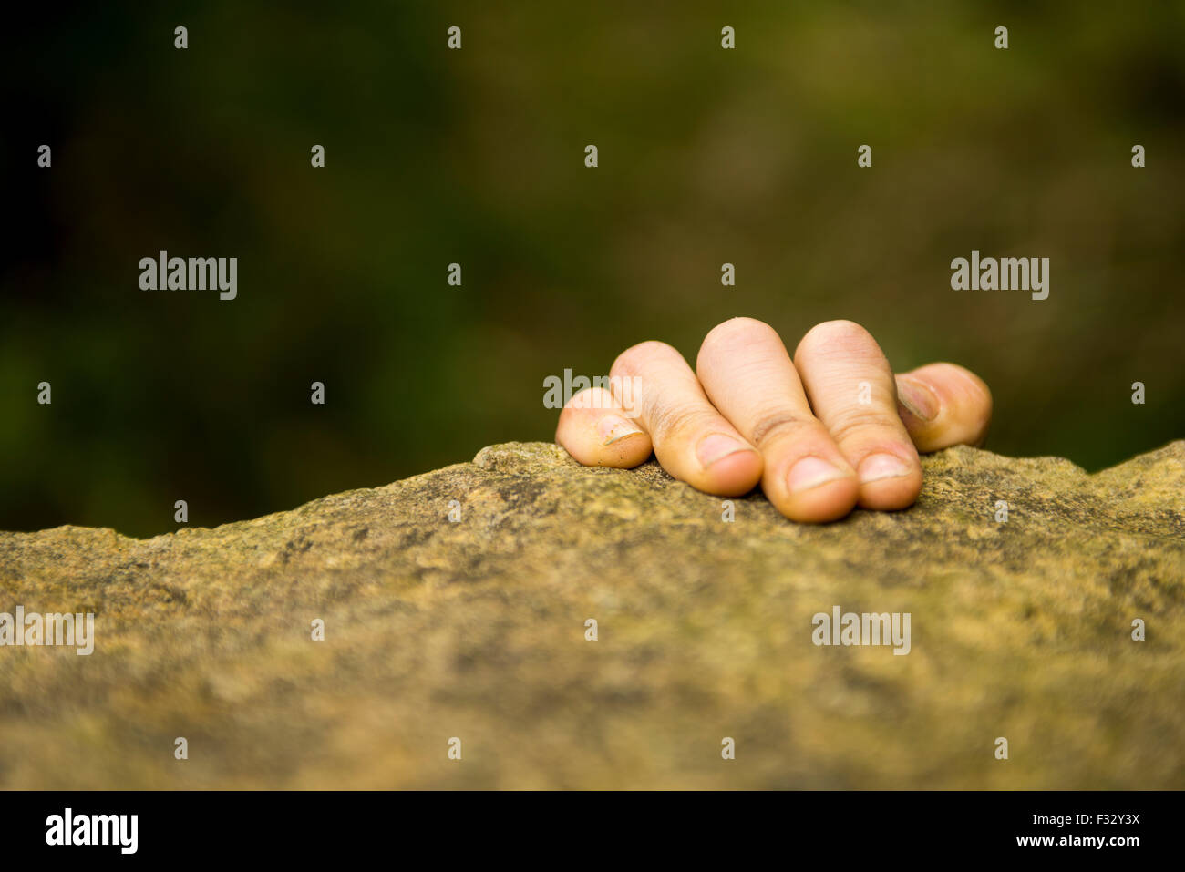 Rock climbers hand on steep rock face Stock Photo - Alamy