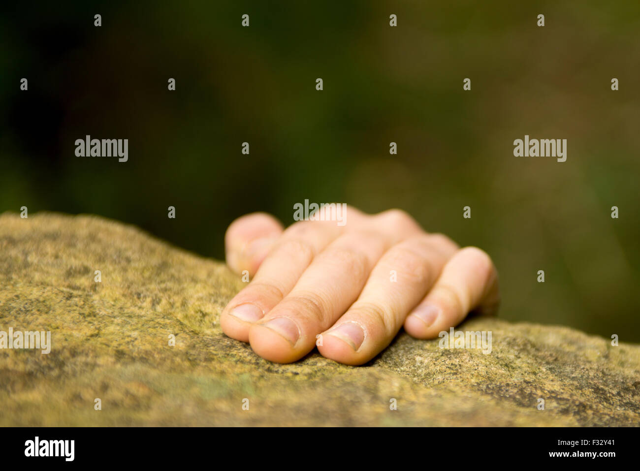 Rock climbers hand on steep rock face Stock Photo - Alamy