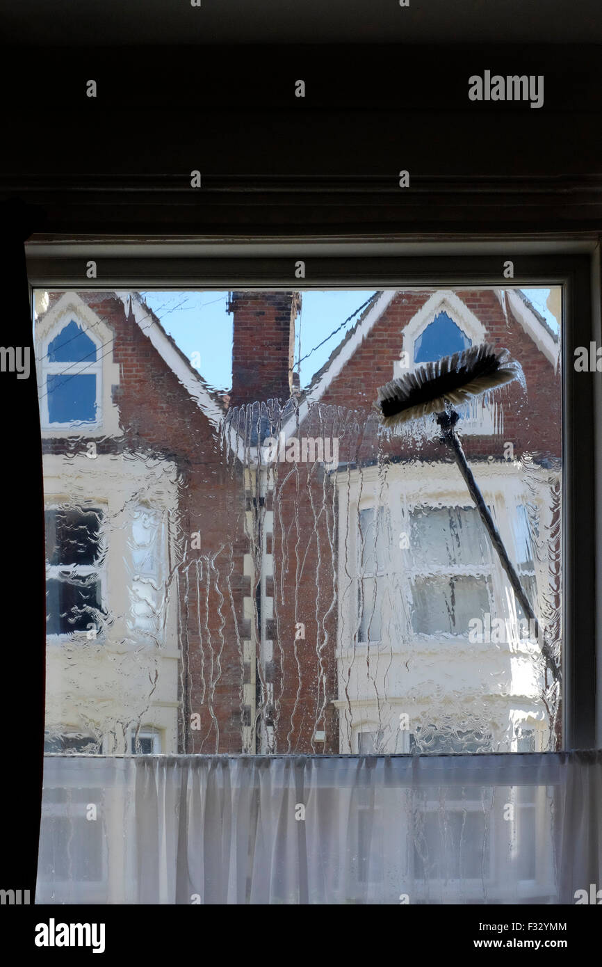 a window cleaners brush sweeps over the glass pane as seen from the ...