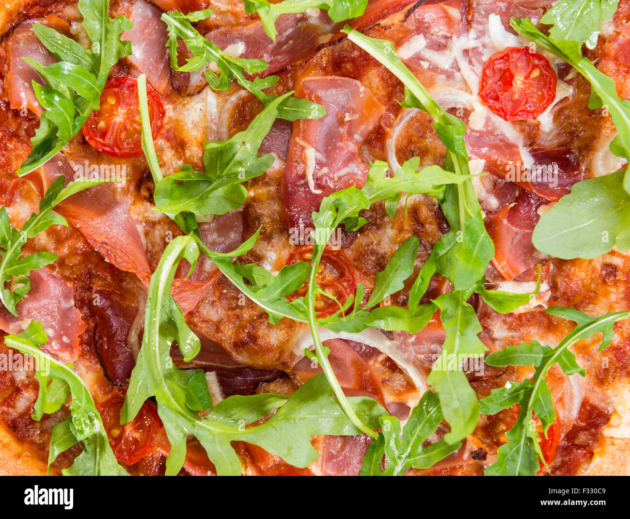 Fresh made Ham Pizza with rocket for use as background image or as ...