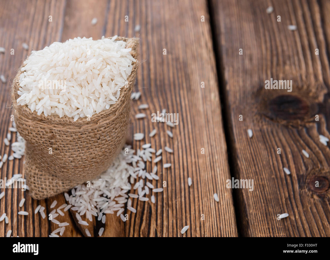 Portion of uncooked Rice on rustic wooden background Stock Photo - Alamy