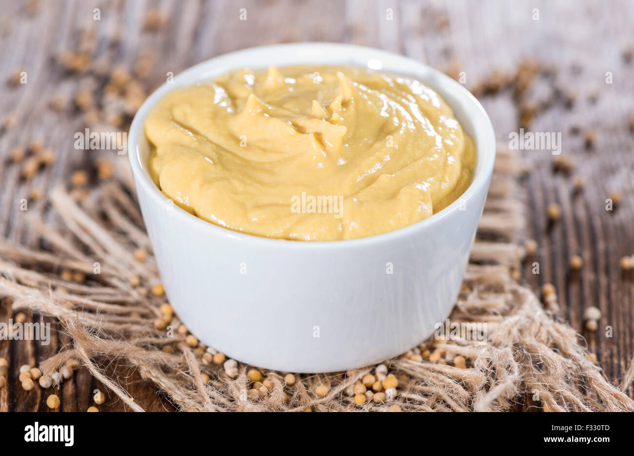 Mustard in a small bowl on vintage wooden backround Stock Photo - Alamy