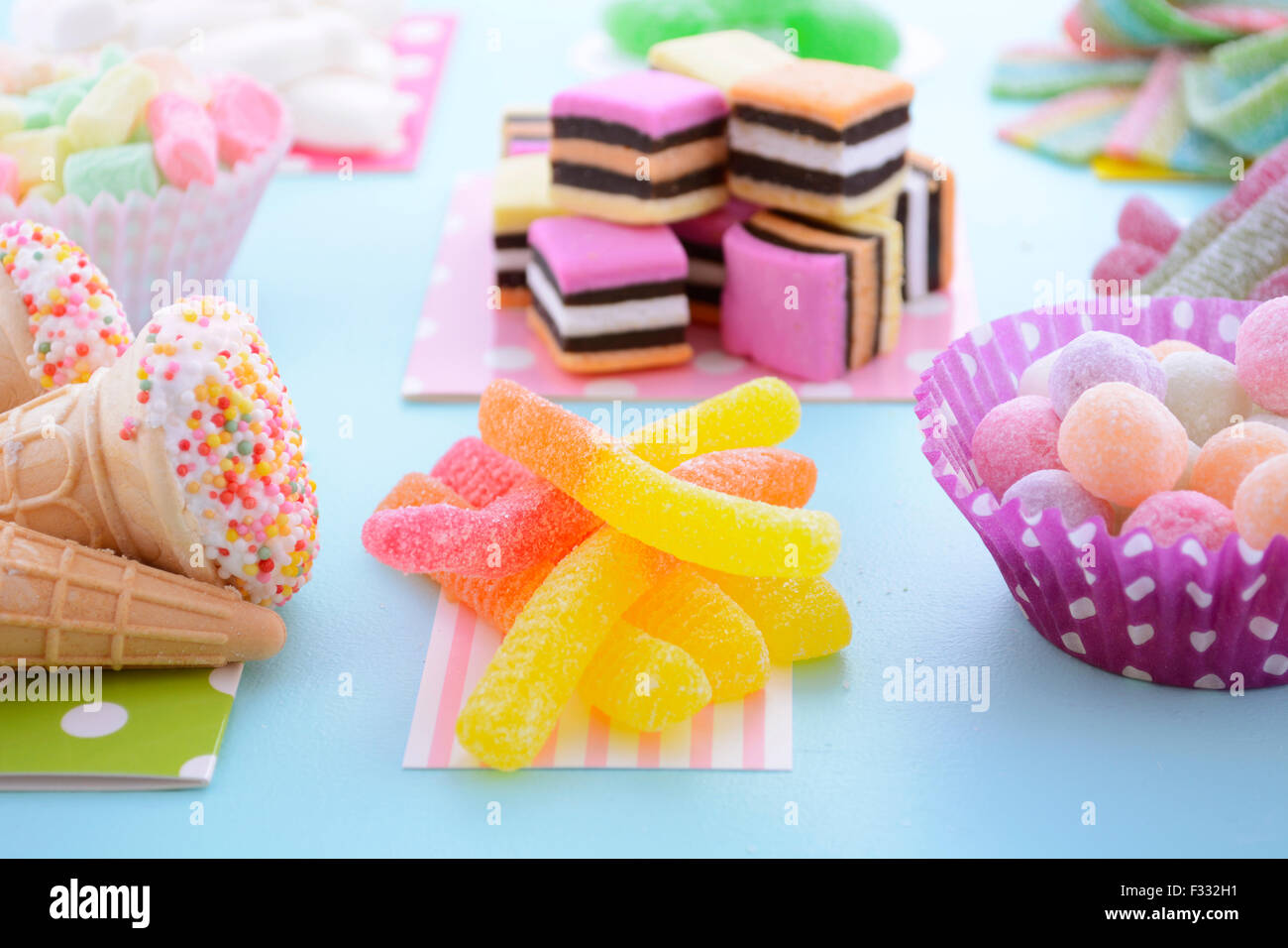 Pile of bright colorful candy on pale blue wood table for Halloween ...