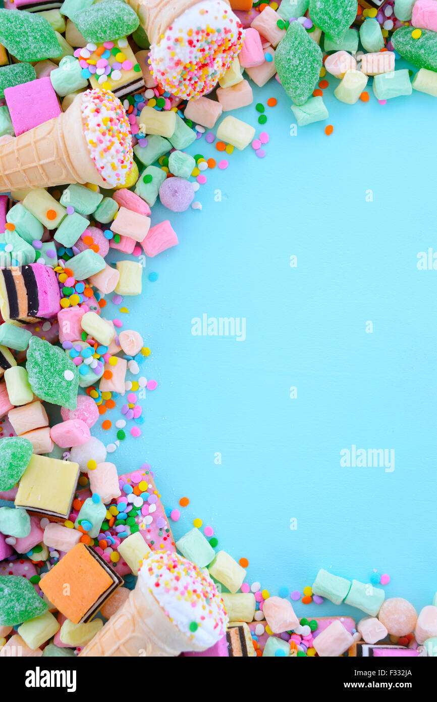 Bright colorful candy on pale blue wood table background with copy ...