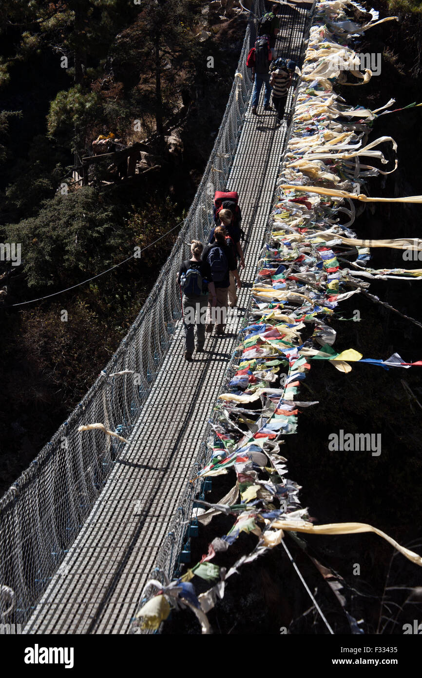 Travellers on steel cable suspension bridge over Dudhkoshi river Nepal ...