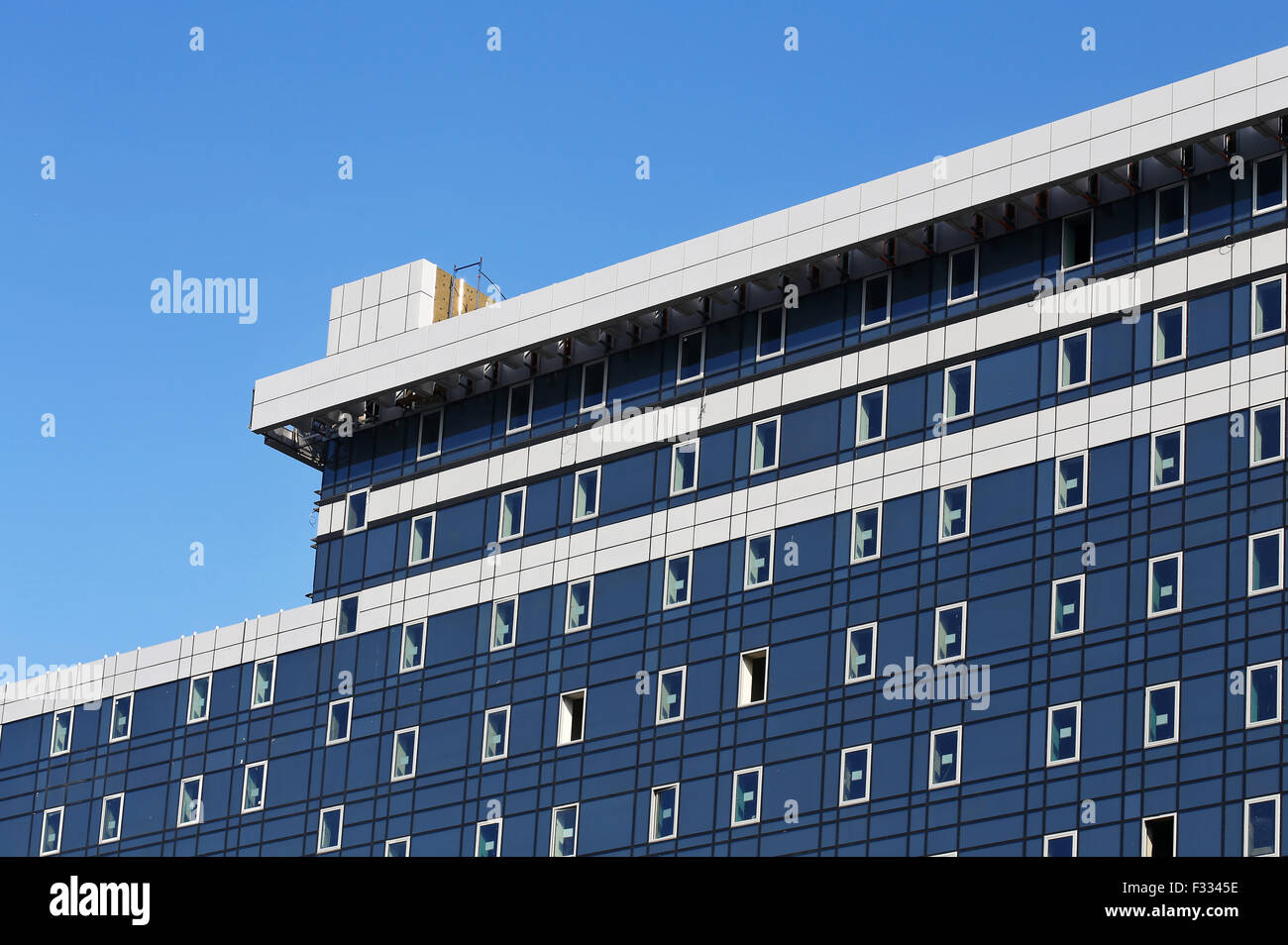 New building’s blue colored wall with windows Stock Photo - Alamy