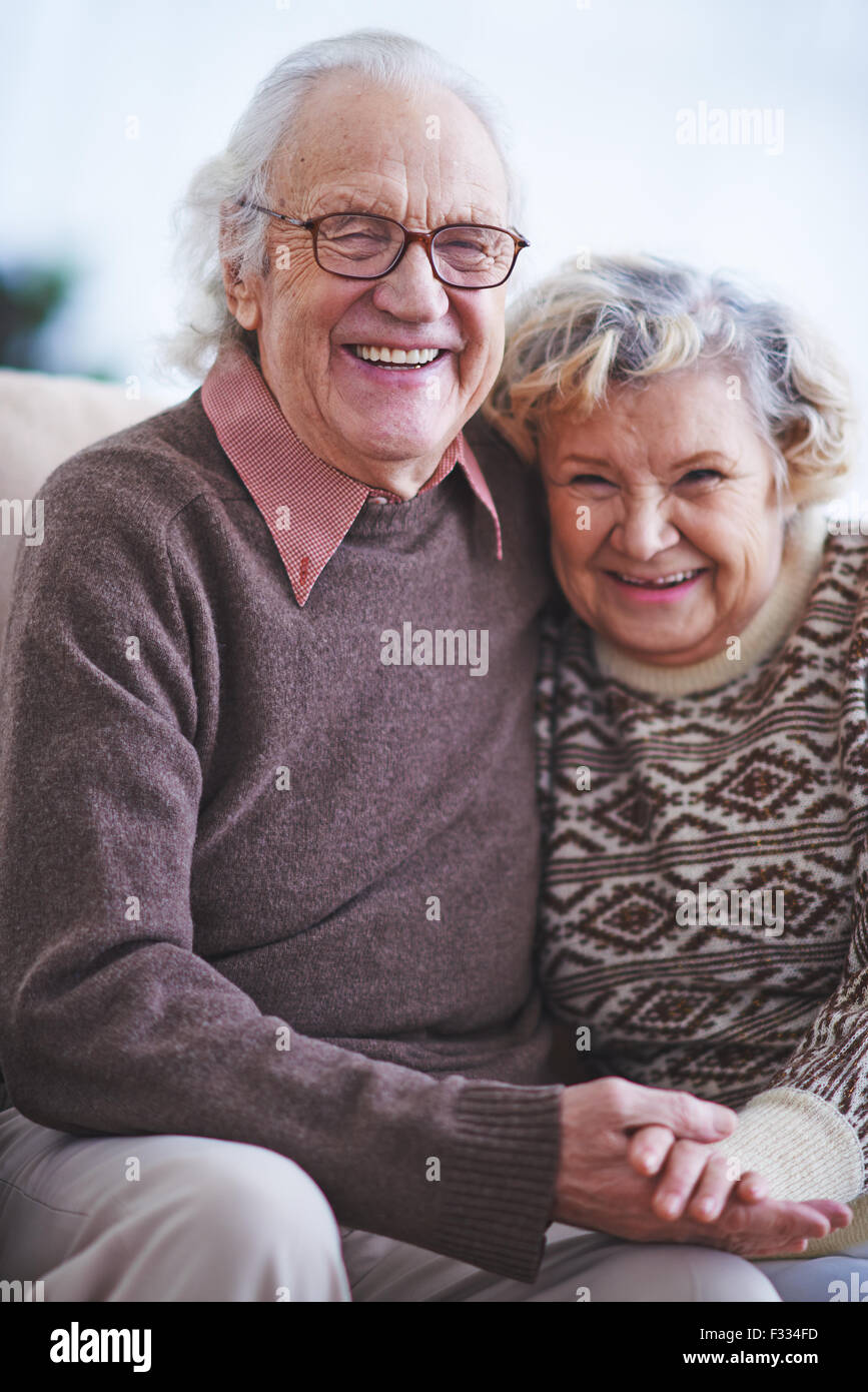 Happy elderly couple looking at camera and laughing Stock Photo - Alamy