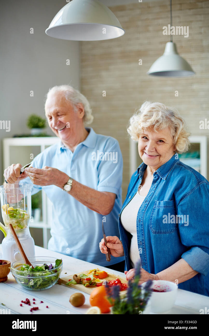 Happy seniors cooking vegetarian food in the kitchen Stock Photo - Alamy