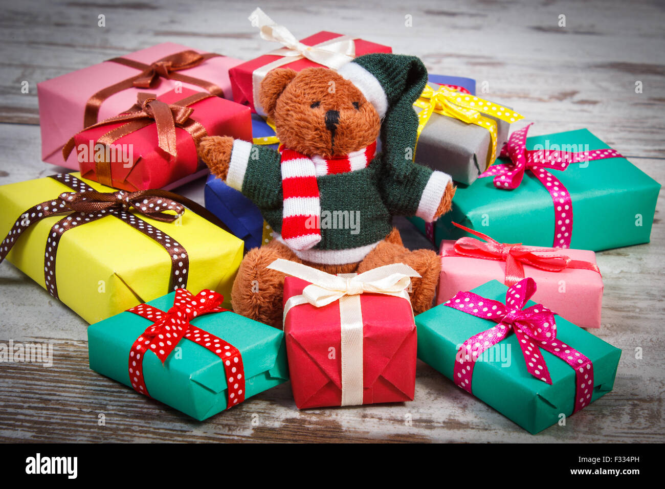 Fluffy teddy bear and heap of wrapped colorful gifts for Christmas ...