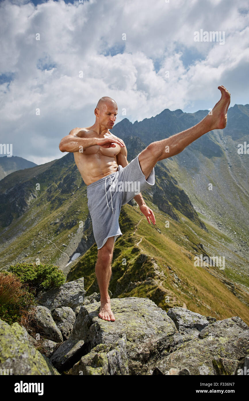 Kickboxer or muay thai fighter practicing shadow boxing on a mountain ...