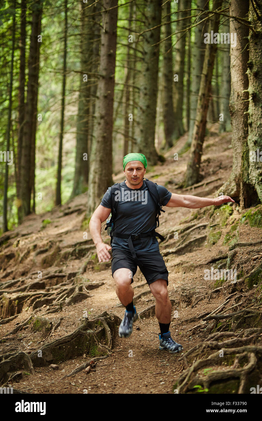Caucasian man running in the pine forest forest, outdoor fitness ...