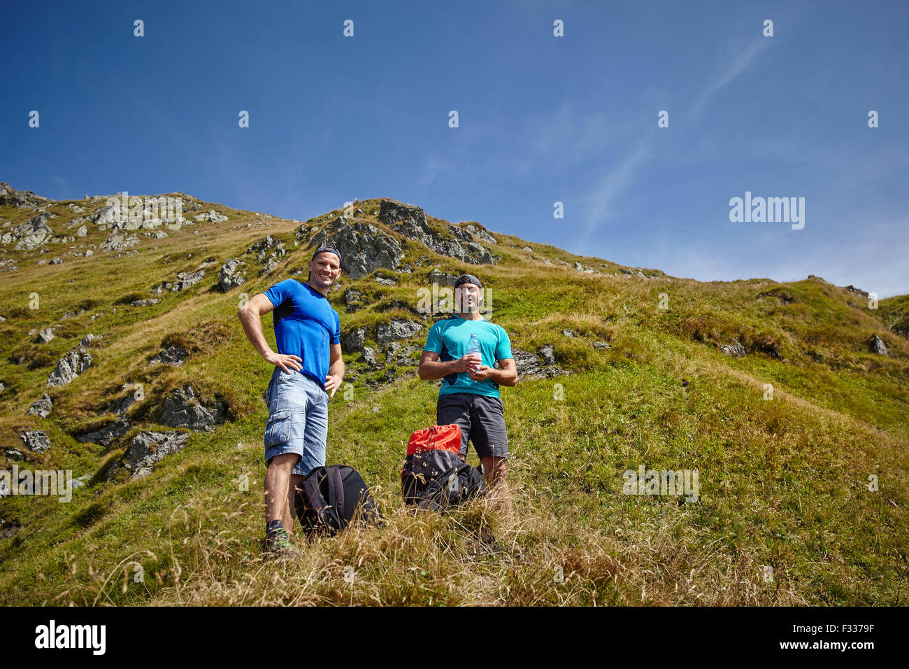 Male hikers having a break on a mountain trail Stock Photo - Alamy