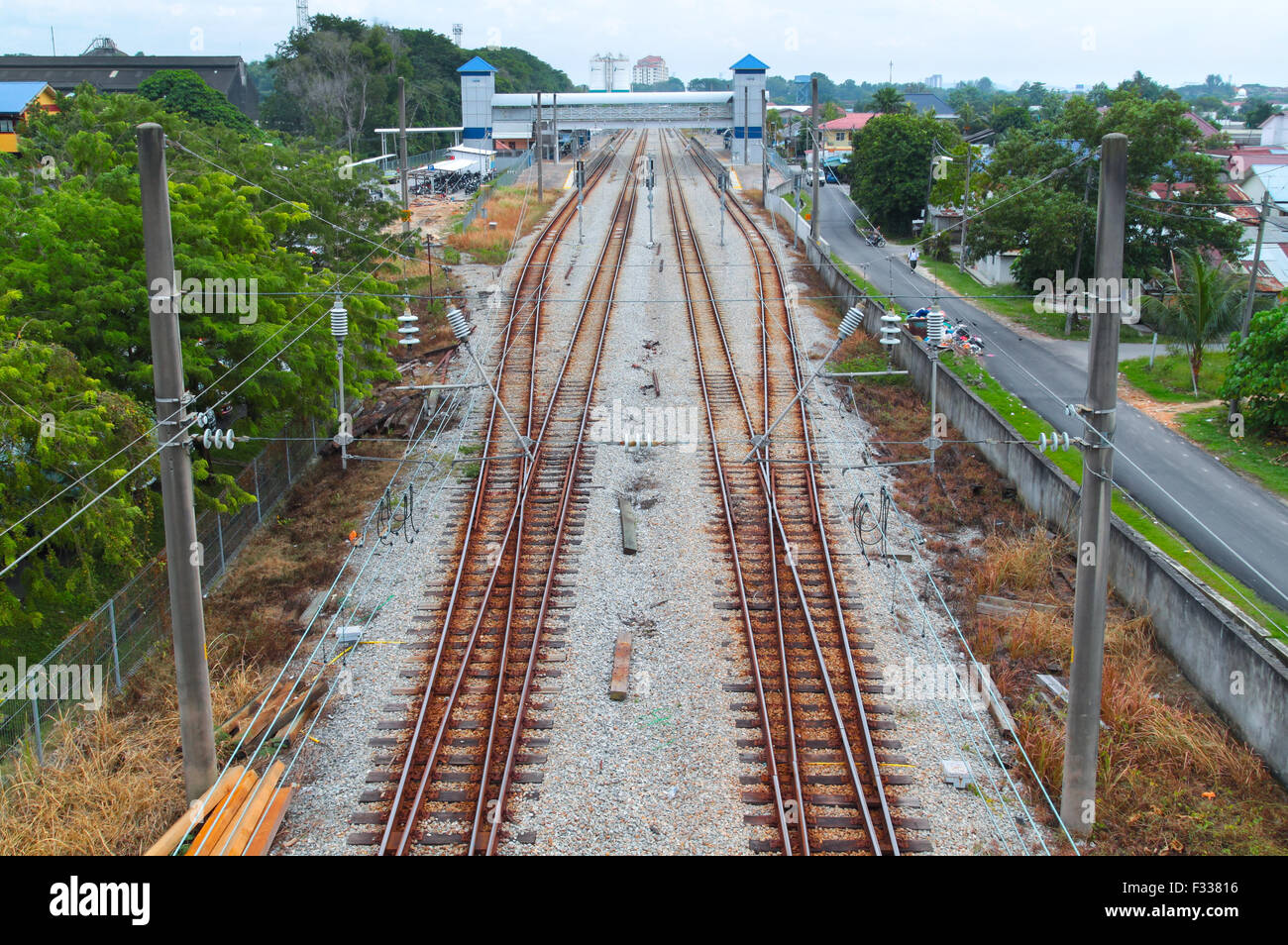 Electric train track beside a rural housing estate Stock Photo - Alamy