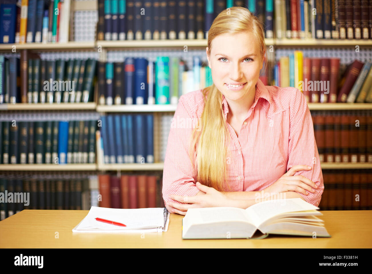 Female student reading a book and making notes Stock Photo - Alamy