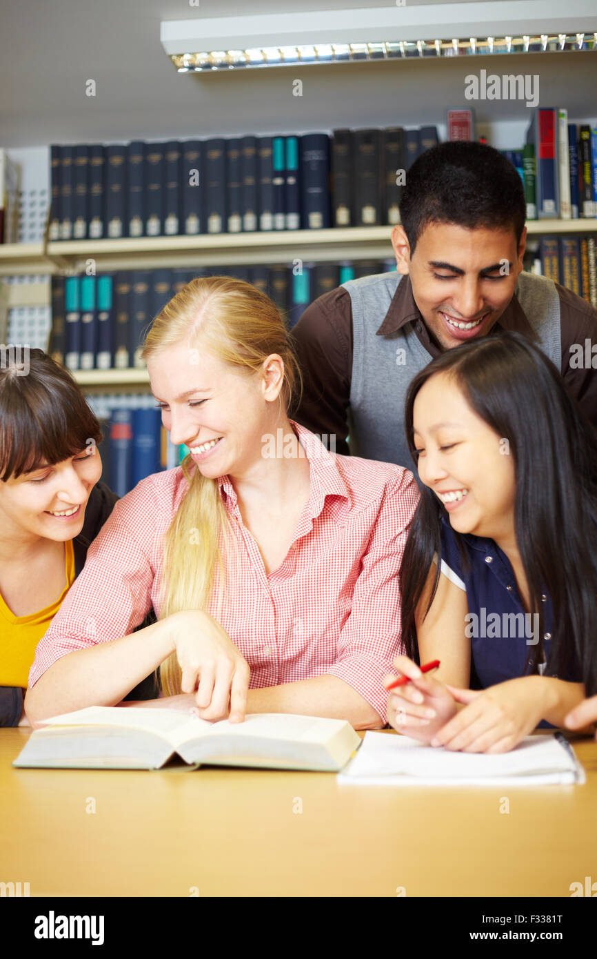 Group of students learning together in library Stock Photo - Alamy