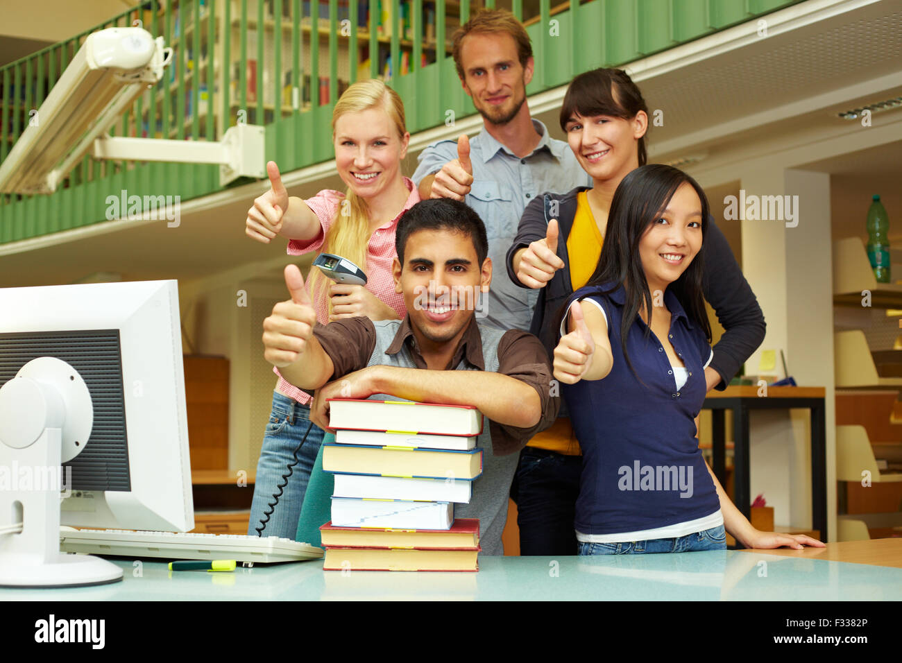 Library staff at university showing their thumbs up Stock Photo - Alamy