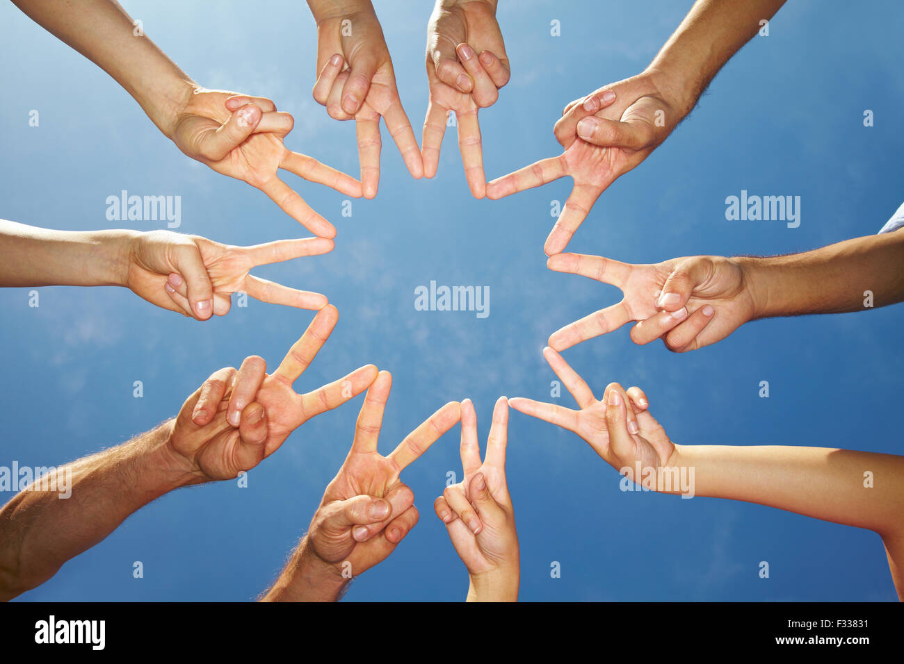 Many hands connecting to star shape under sky Stock Photo - Alamy