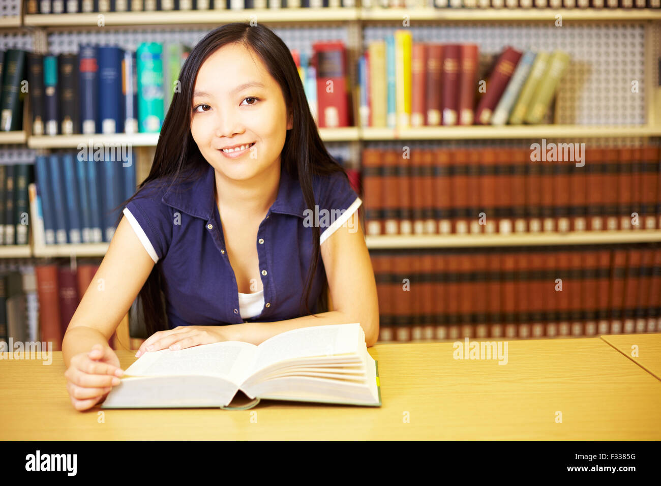 Asian student reading book in a library Stock Photo - Alamy
