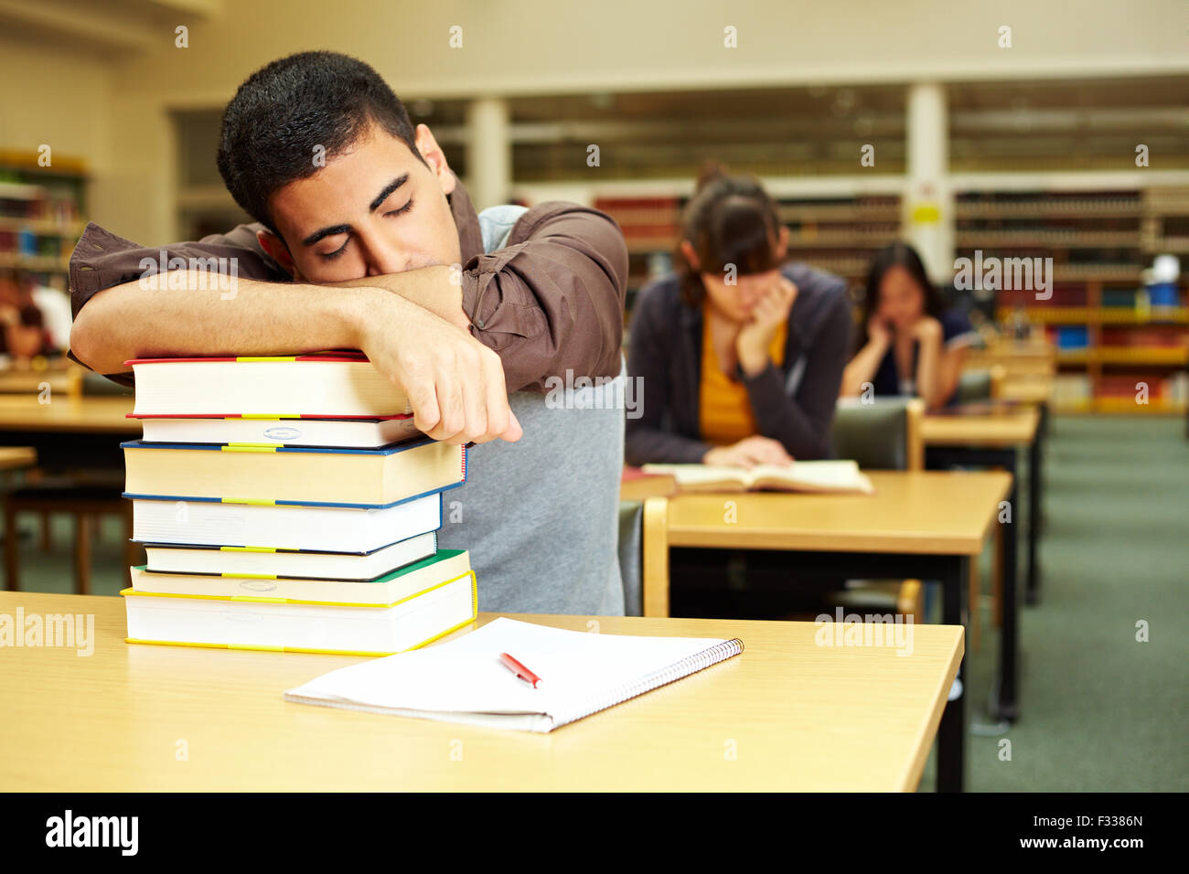 Student sleeping in reading room of university library Stock Photo - Alamy