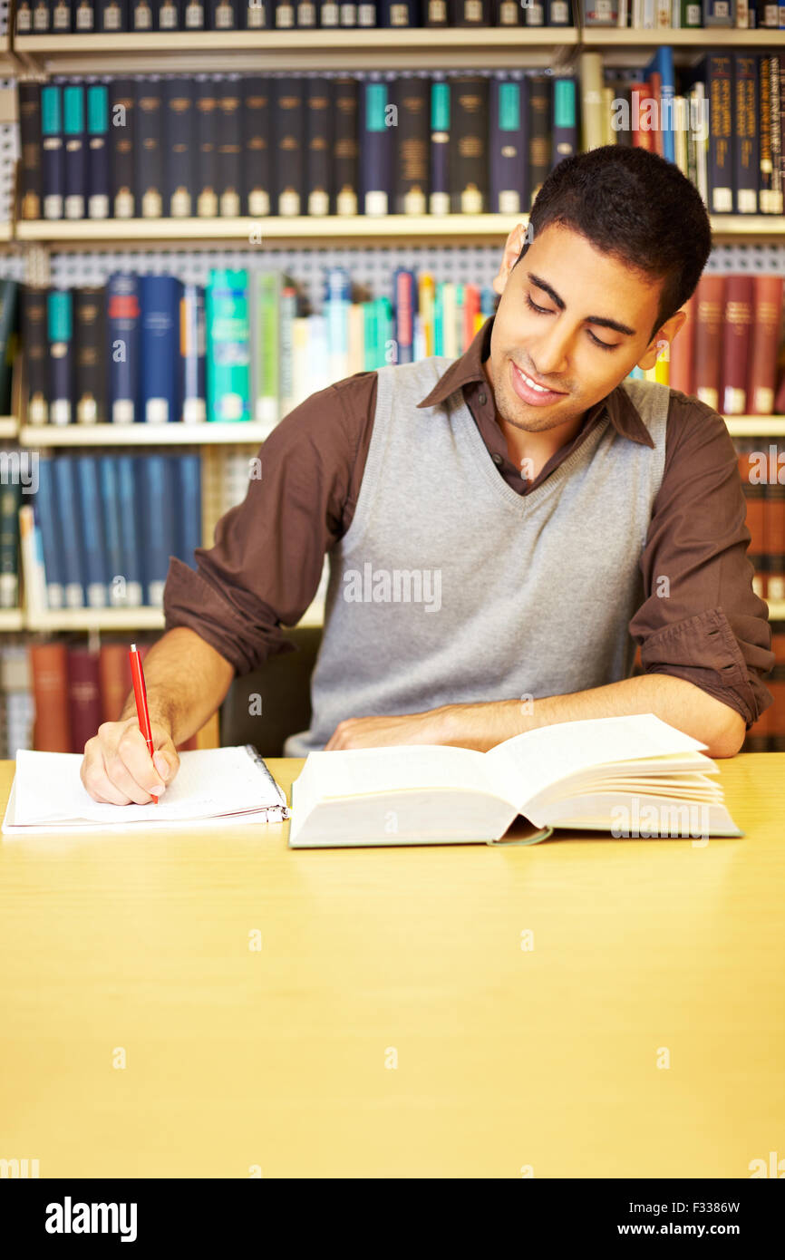 Student reading a book and taking notes Stock Photo - Alamy