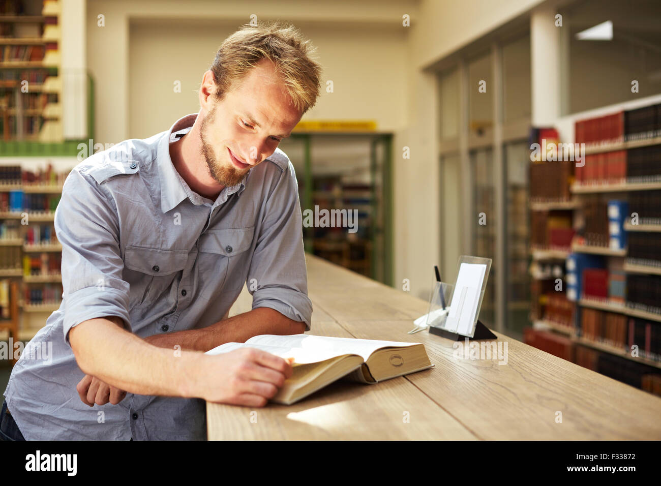 Student reading a book in library archive Stock Photo - Alamy