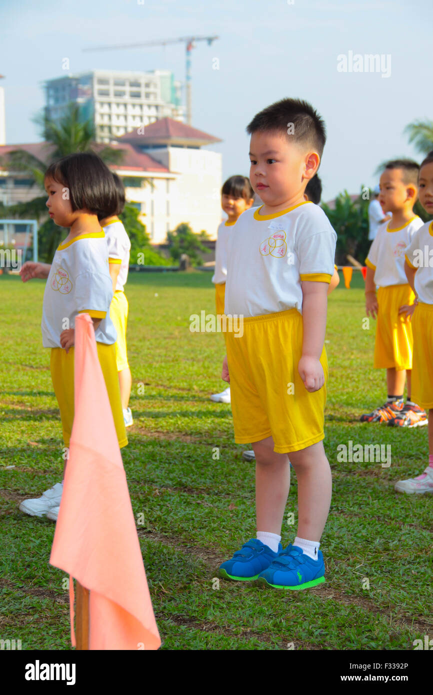 Kindergarten children standing straight on school field during their ...