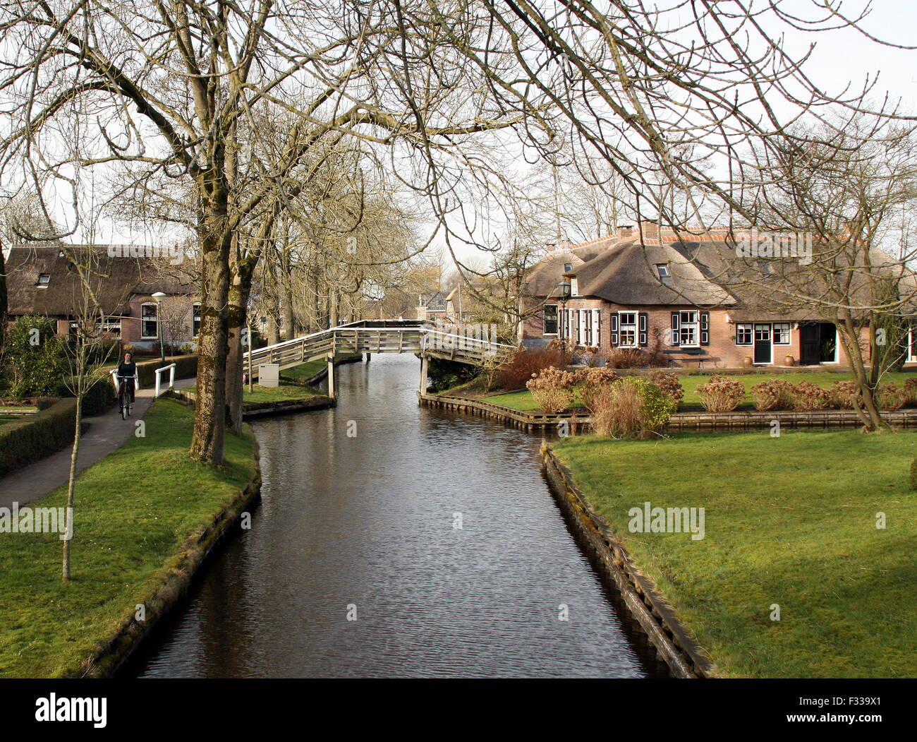 Canal with wooden bridge and traditional houses in Giethoorn. The ...