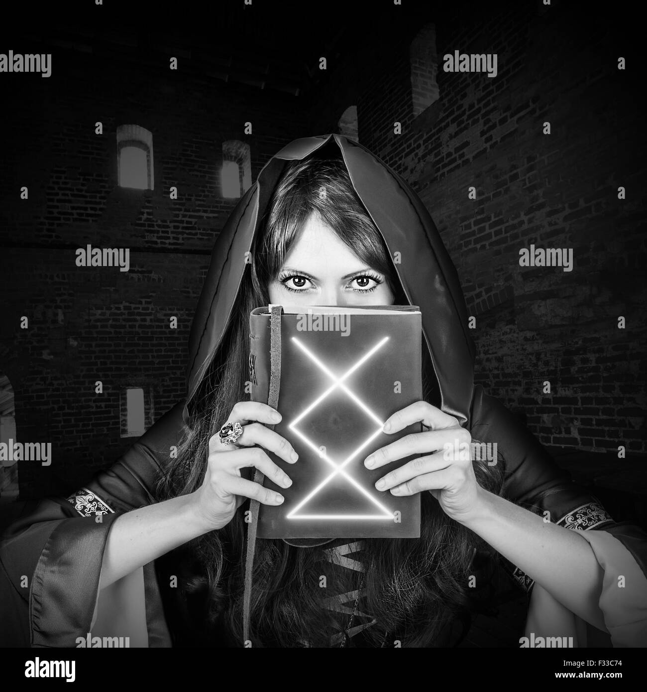 Beautiful young halloween witch wearing vintage gothic dress with hood ...