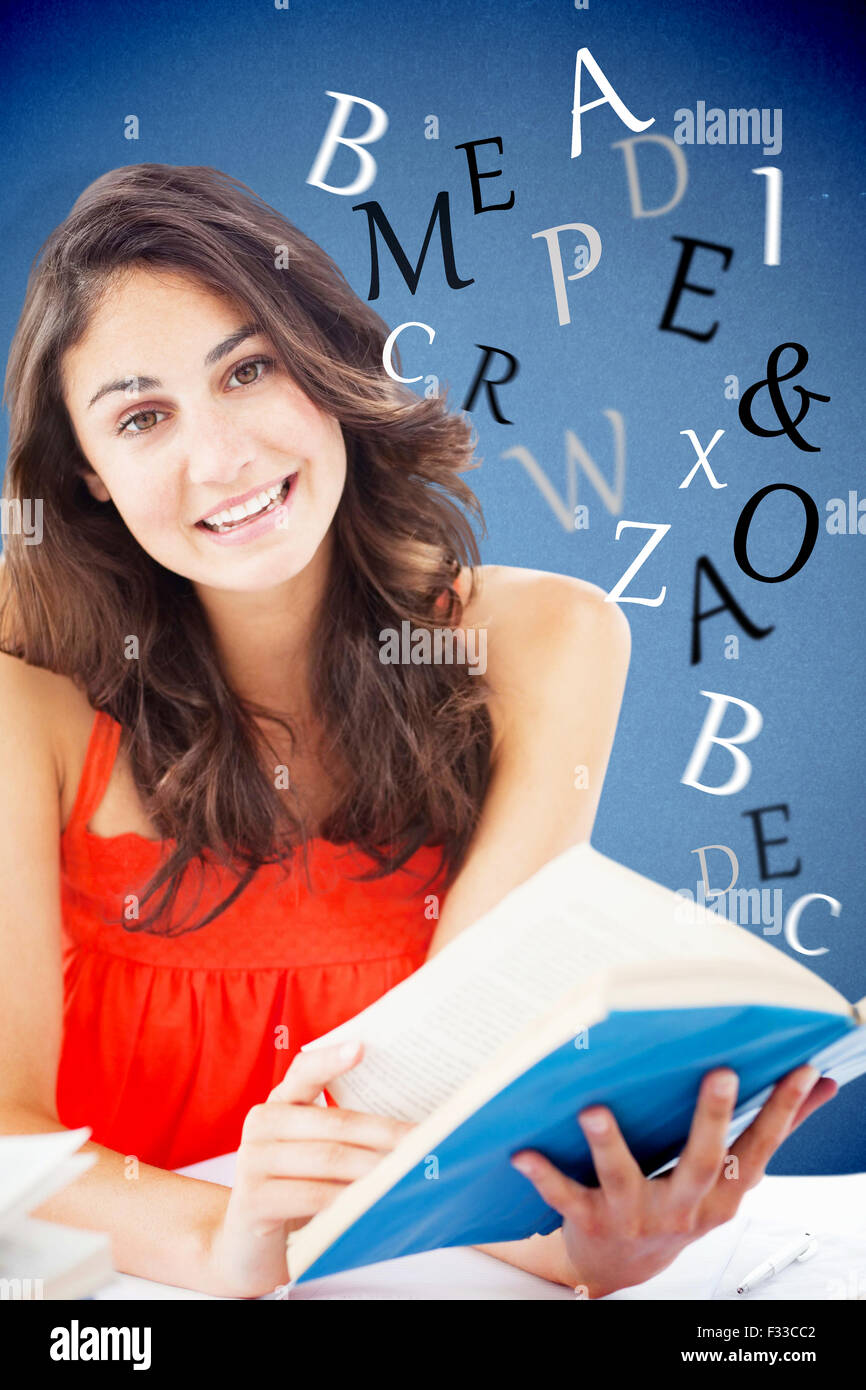 Composite image of portrait of a beautiful student reading a blue book ...