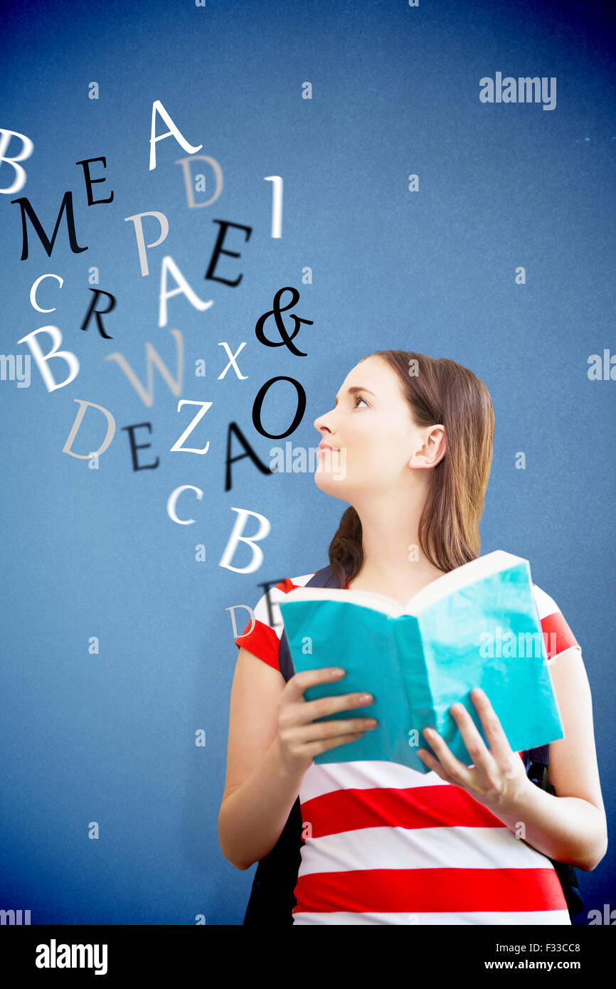 Composite image of student reading book in library Stock Photo - Alamy