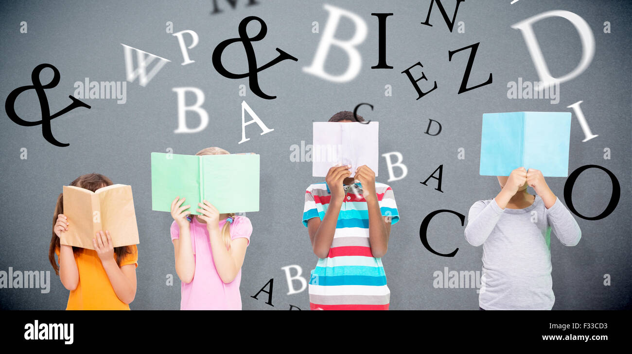 Composite image of elementary pupils reading Stock Photo - Alamy