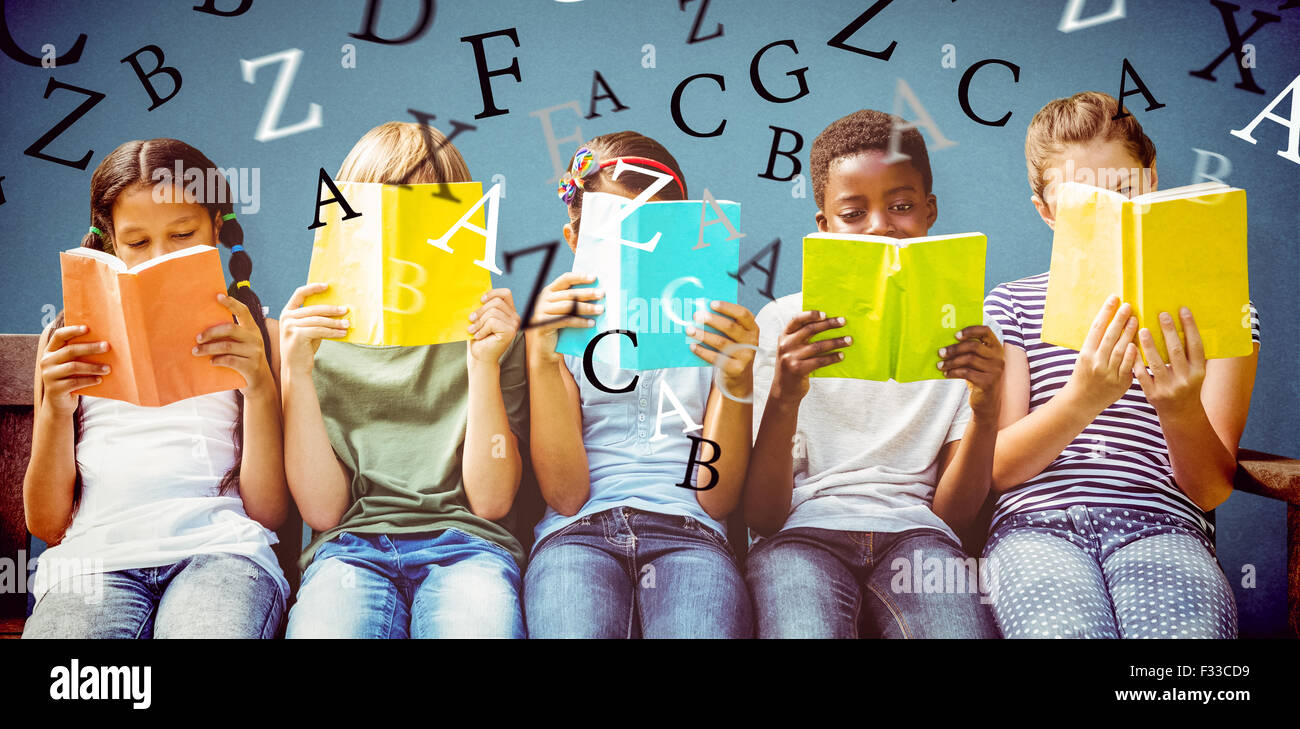 Composite image of children reading books at park Stock Photo - Alamy