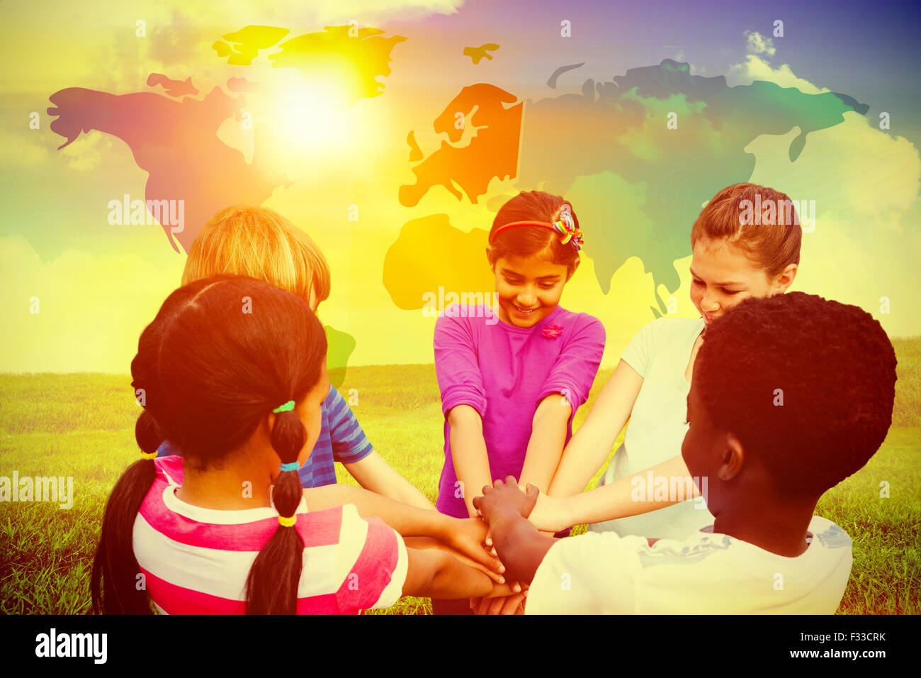 Composite image of children holding hands together at park Stock Photo ...