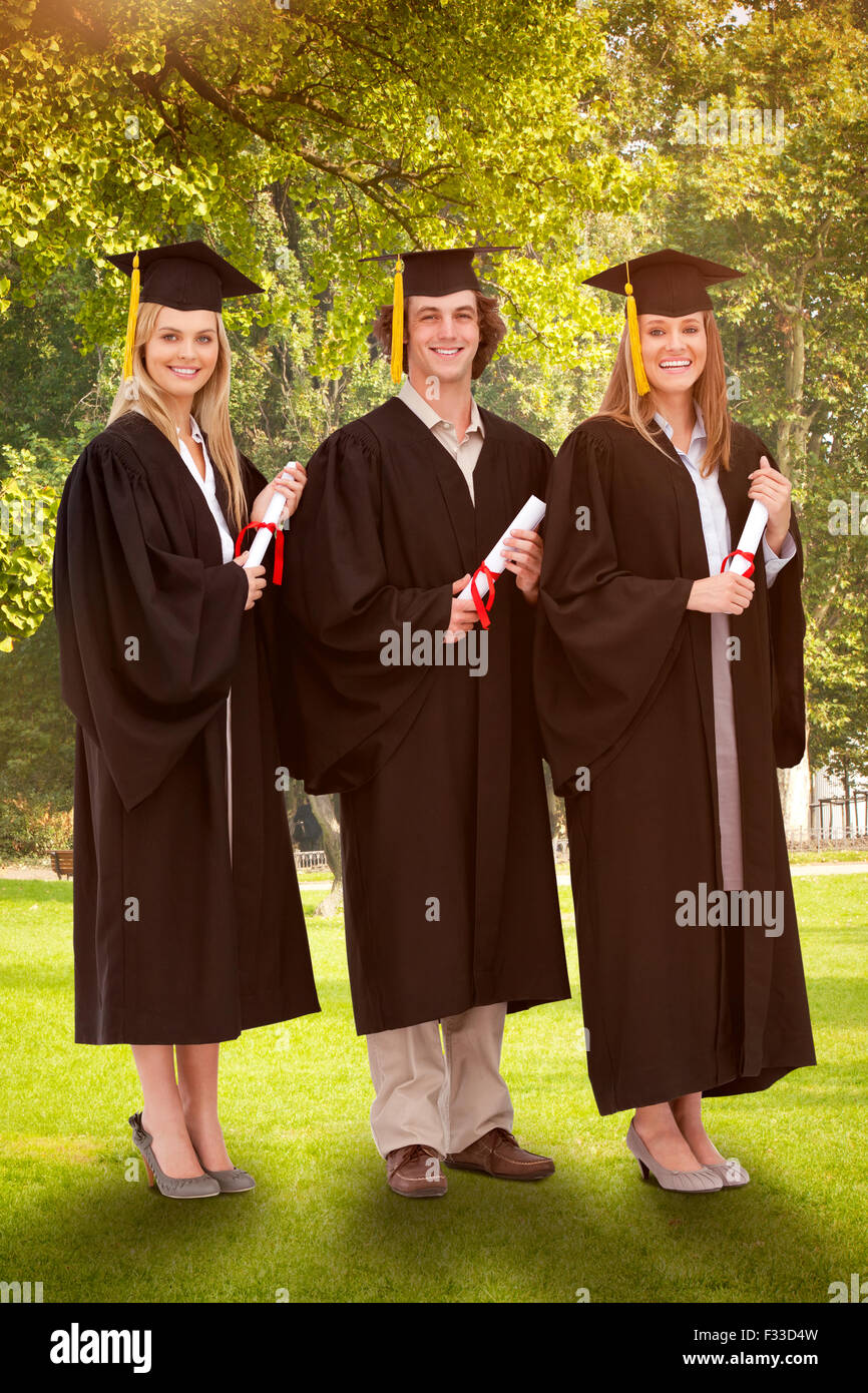 Composite image of three smiling students in graduate robe holding a ...