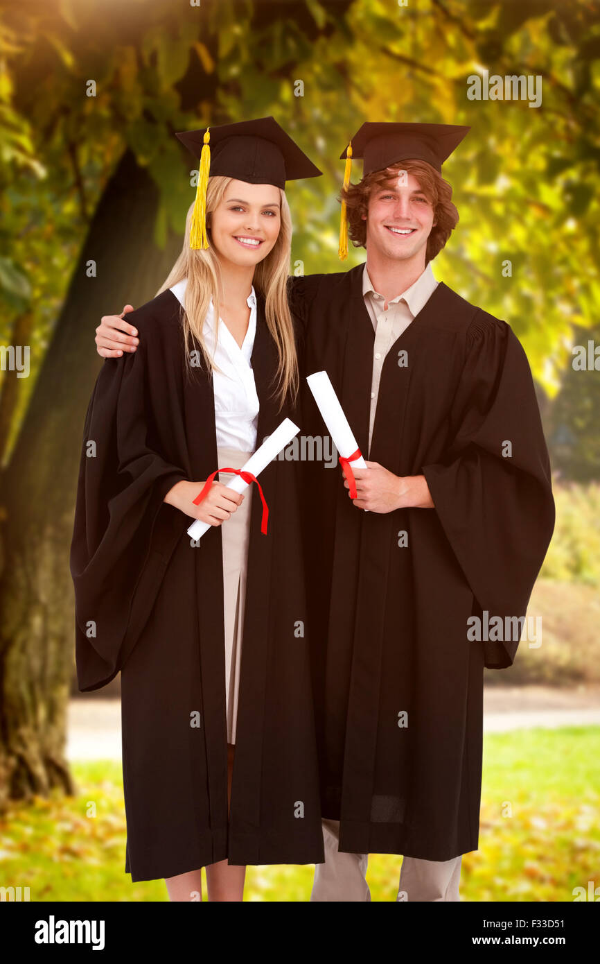 Composite image of two students in graduate robe shoulder to shoulder ...