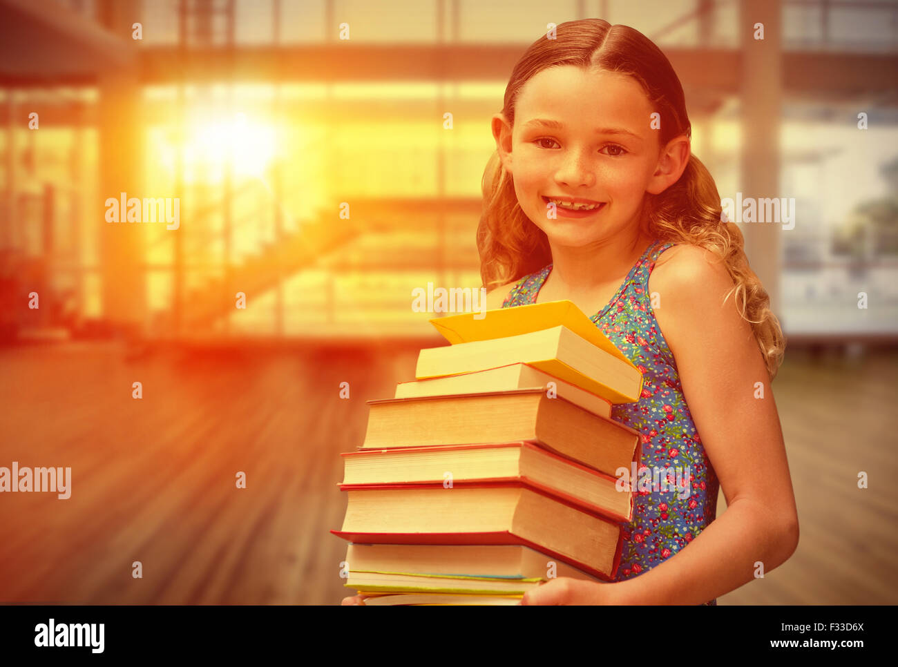 Composite image of cute little girl carrying books in library Stock ...